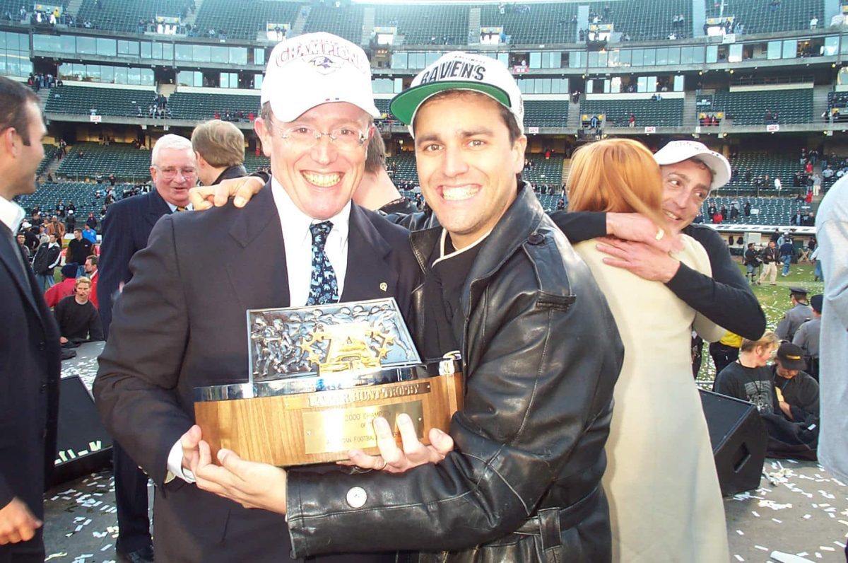 Nasty hugs the Lamar Hunt AFC Championship Trophy with David Modell ...